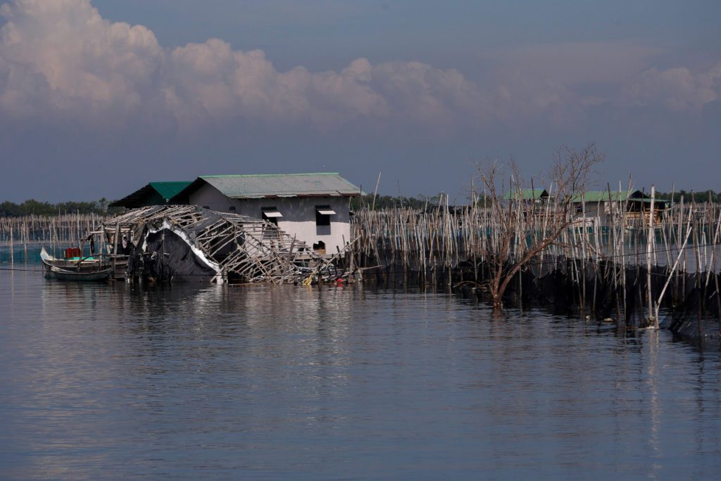 Climate change and rising sea levels devour a village at Manila Bay